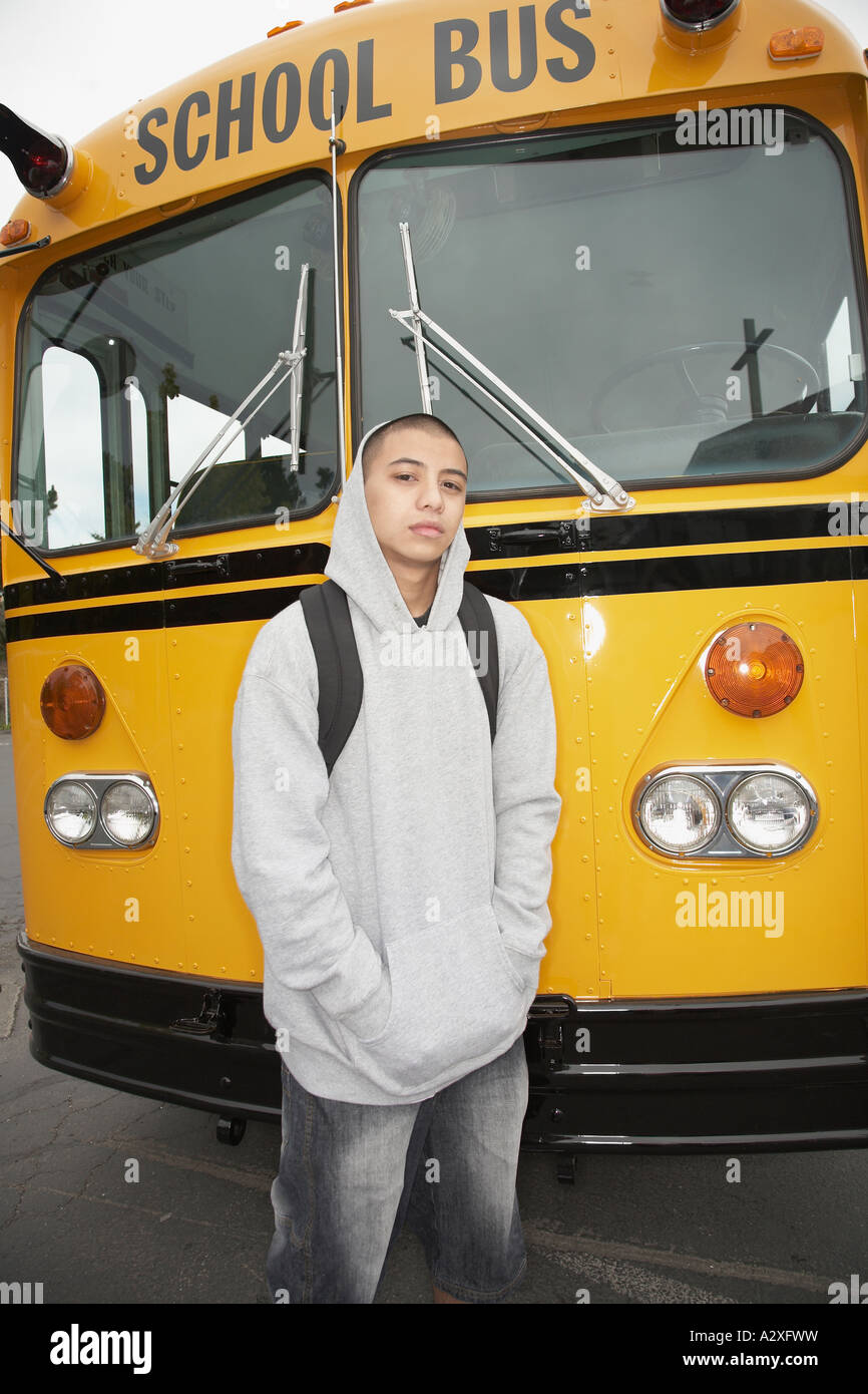 Young man with backpack next to school bus Stock Photo - Alamy