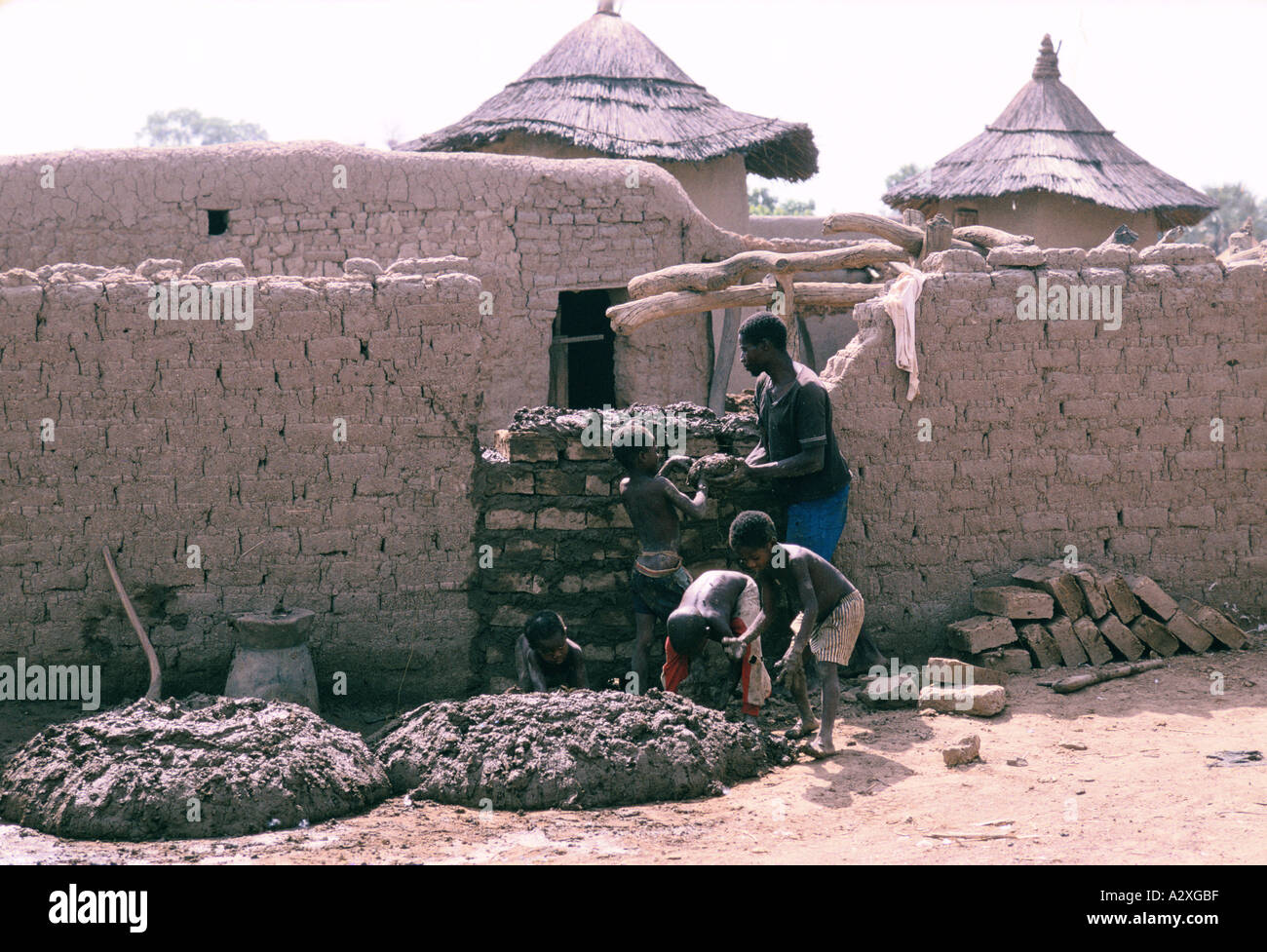 mali west africa 1995 children help their father repair mud walls ...