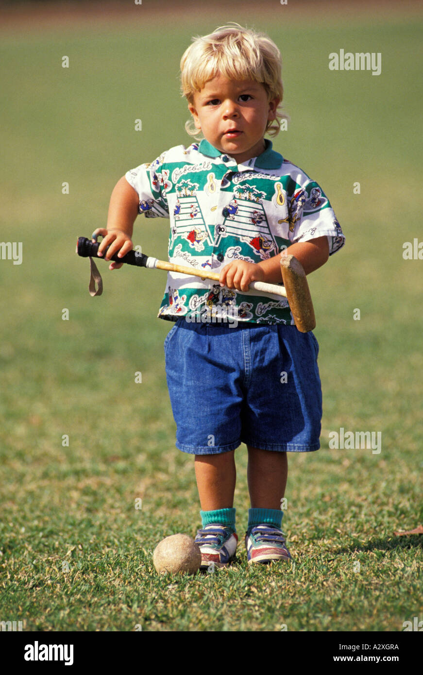 Caribbean Dominican Republic Young boy playing with mallet and ball ...