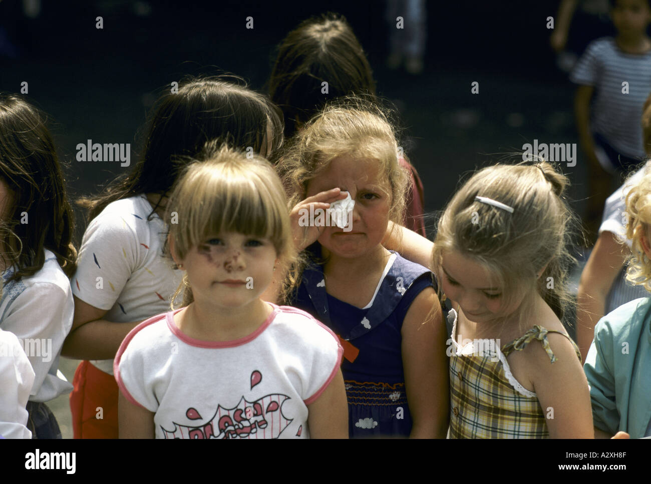 girl crying in playground she had been kicked by a boy Stock Photo - Alamy