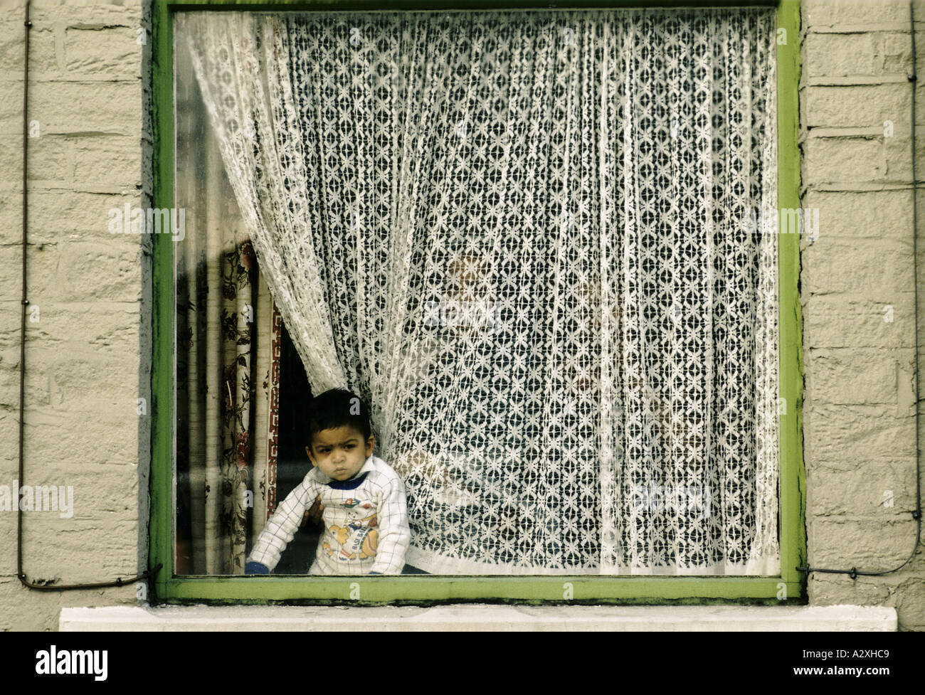 young child looking out of window bradford Stock Photo - Alamy
