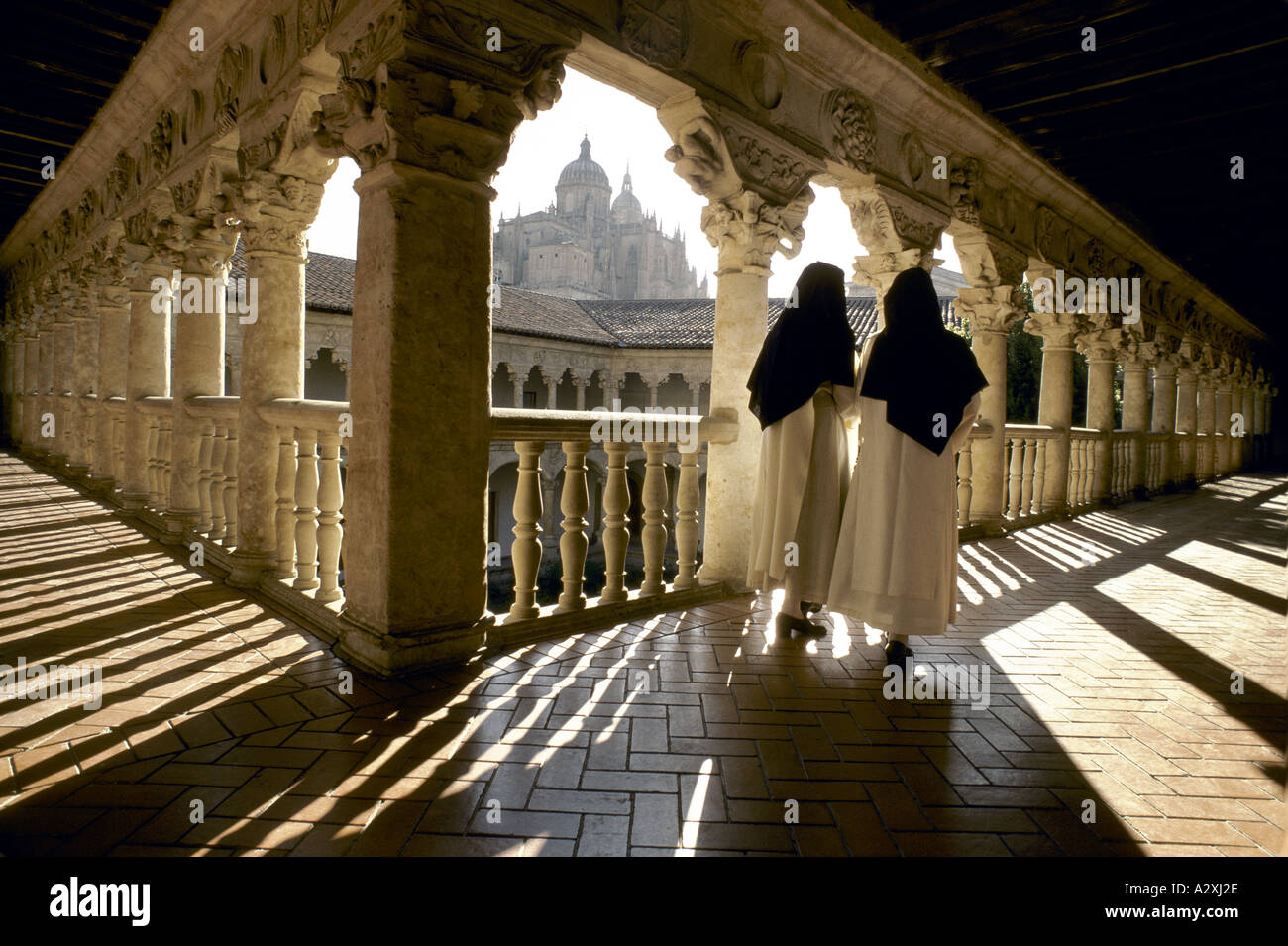 two nuns walking along balcony surrounding courtyard of historic ...