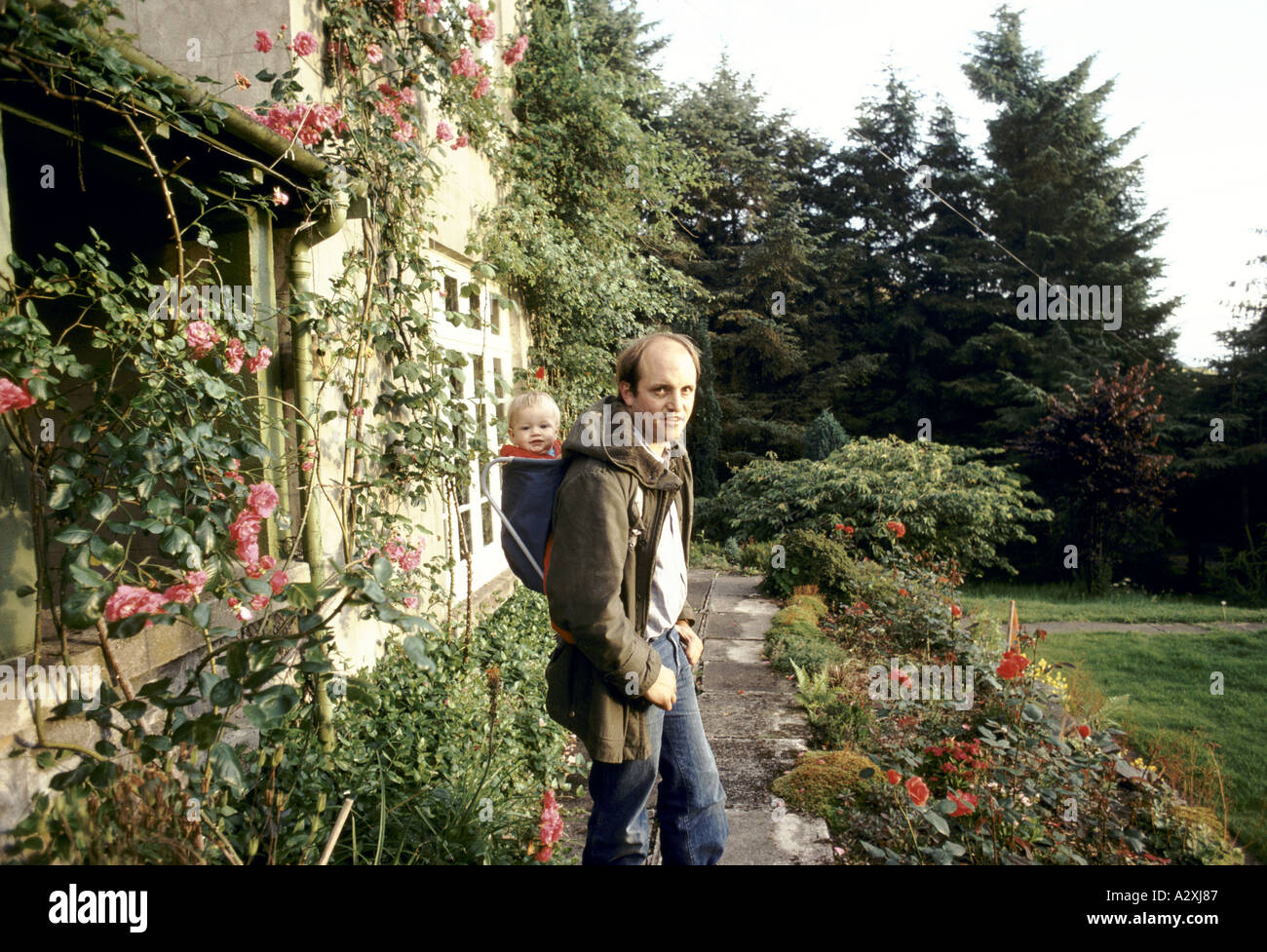 man carrying child on his back using baby carrier Stock Photo - Alamy