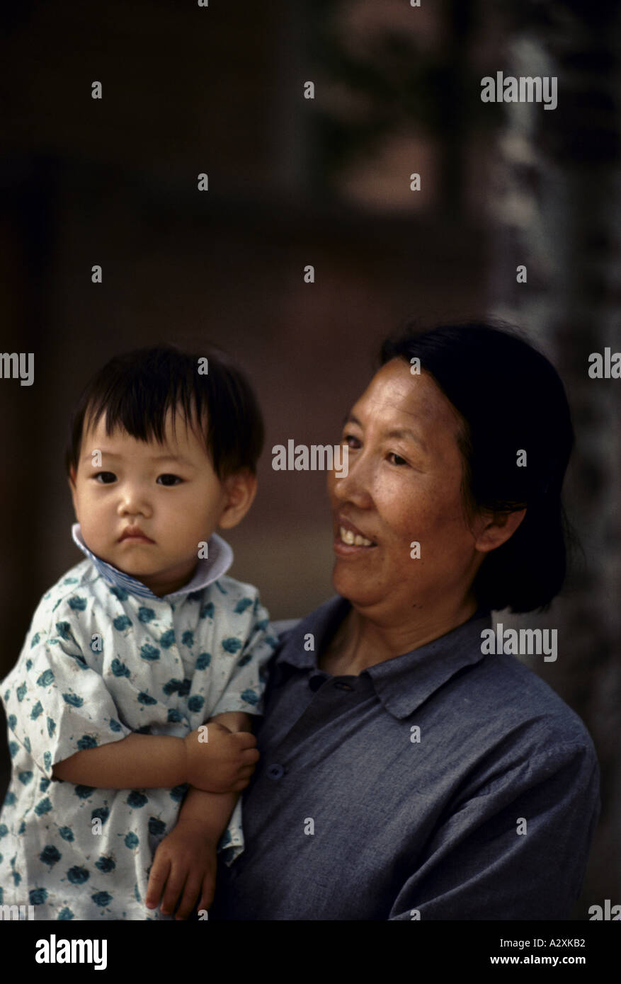 woman holding little chinese boy in her arms Stock Photo - Alamy