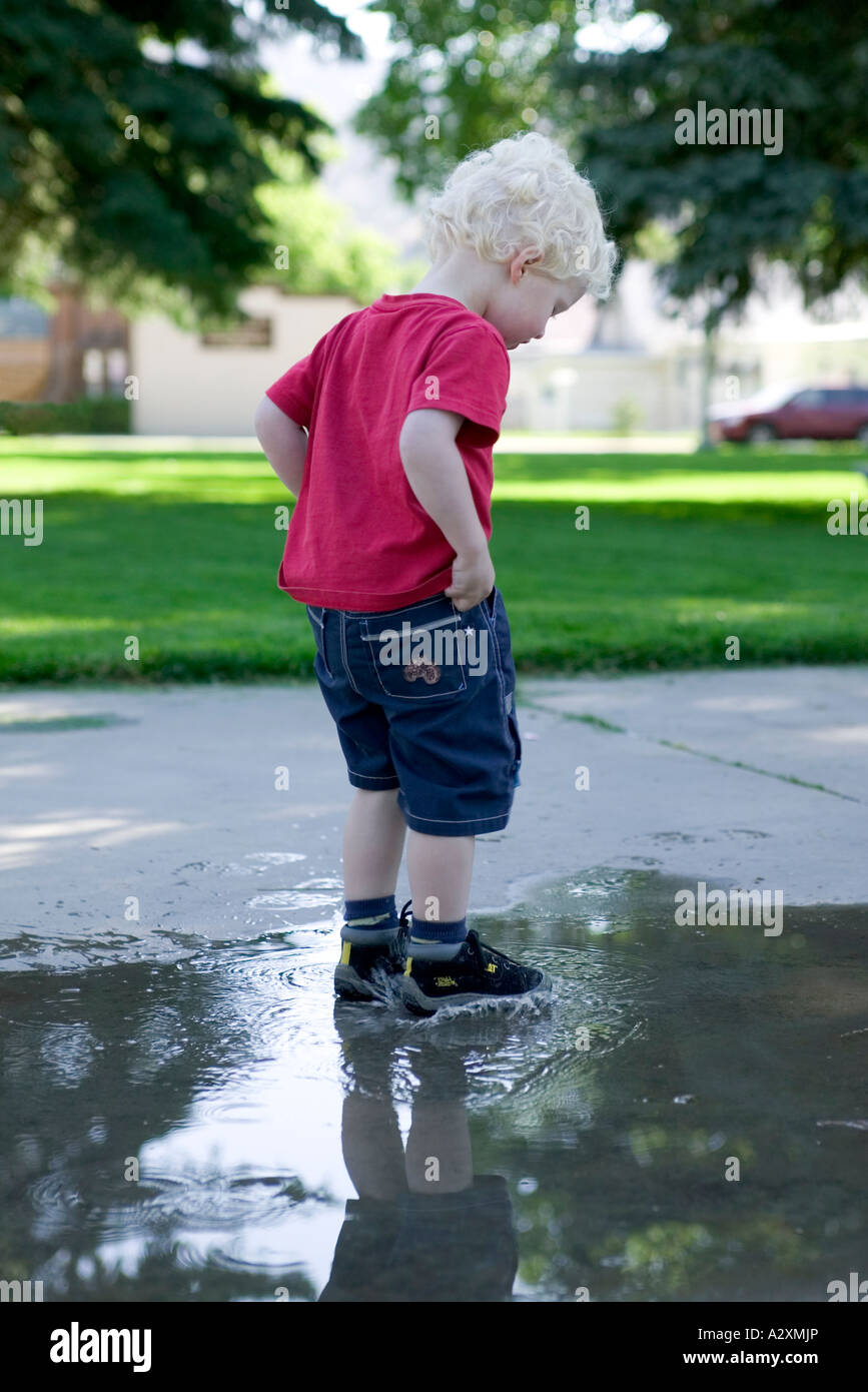 Toddler Boy Splashes In Puddle On Town Playground, Salida, Colorado ...