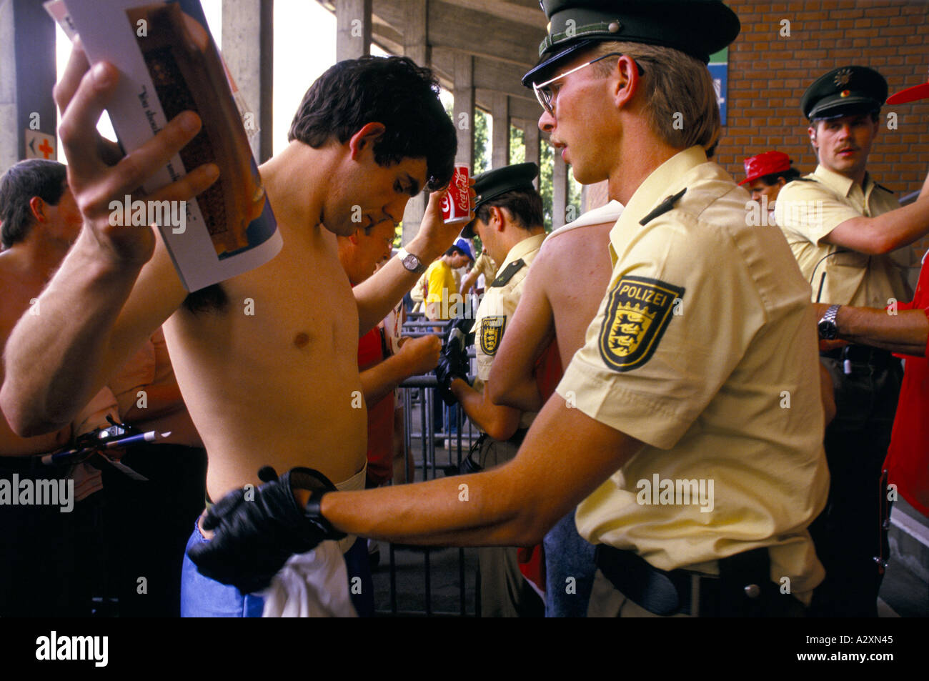 German policeman search English football fans entering a stadium before ...