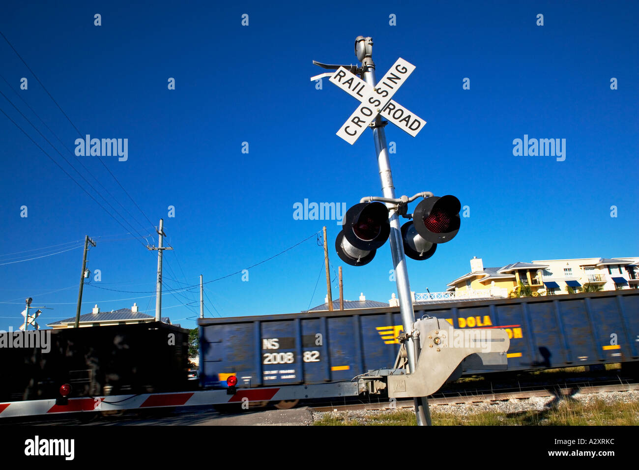 RAILROAD CROSSING WITH TRAIN PASSING BY Stock Photo - Alamy