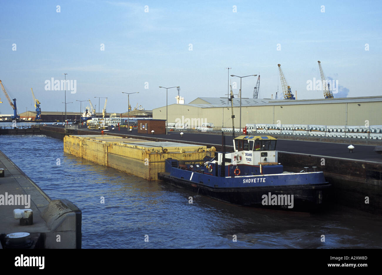 Lash barges and tug entering the King George Dock Lock Stock Photo - Alamy