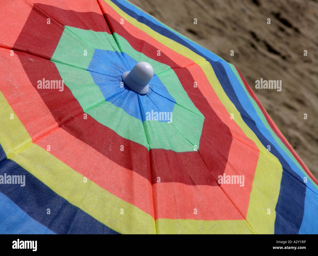 Brightly coloured parasol on a beach Stock Photo - Alamy