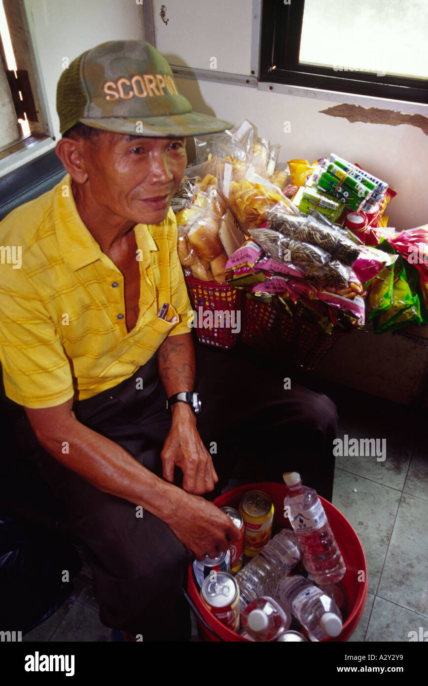 Train vendor sells refreshments and snacks on board the Tenom train ...