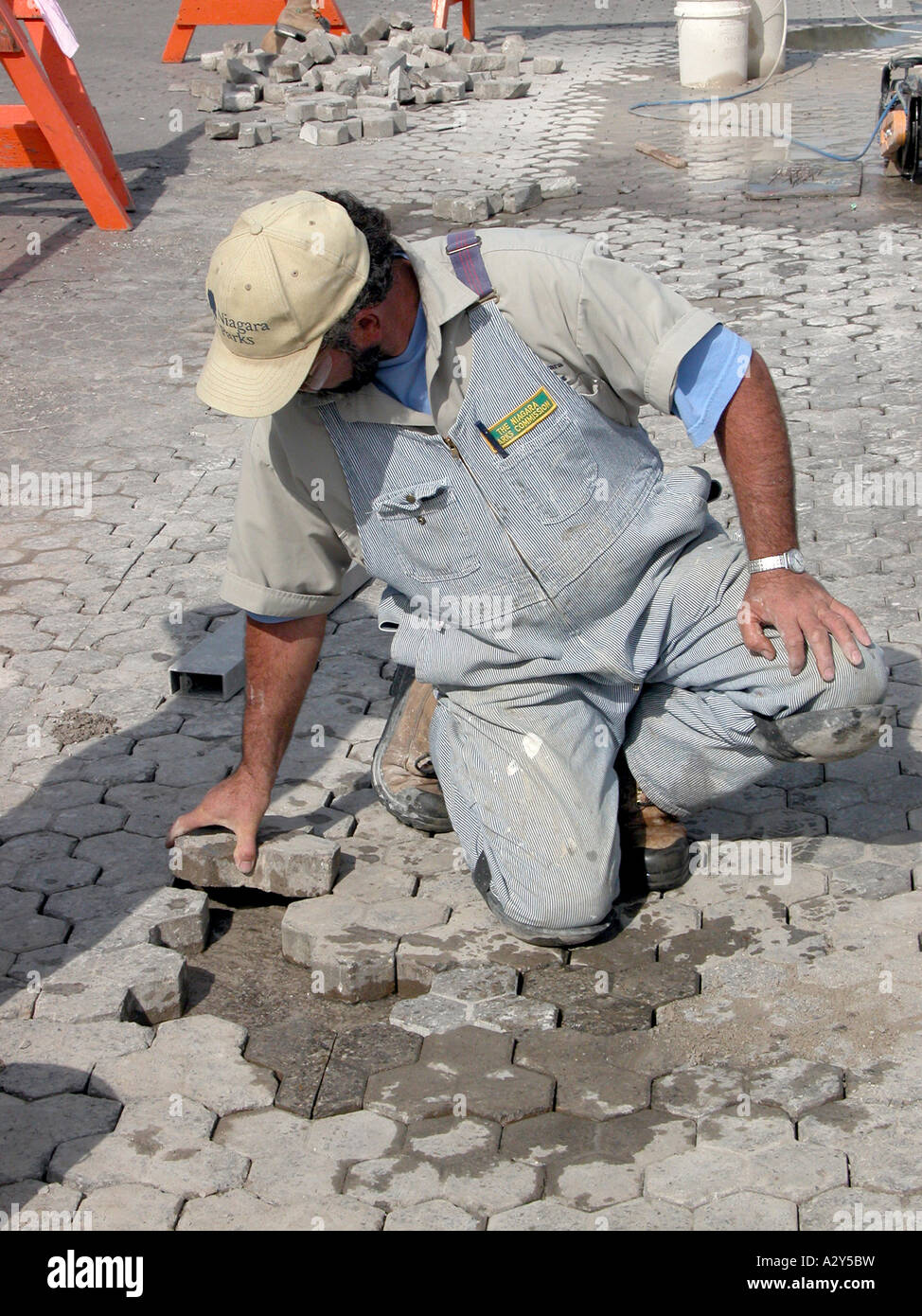 Mason cement workers lay decorative stones in a sidewalk Stock Photo ...