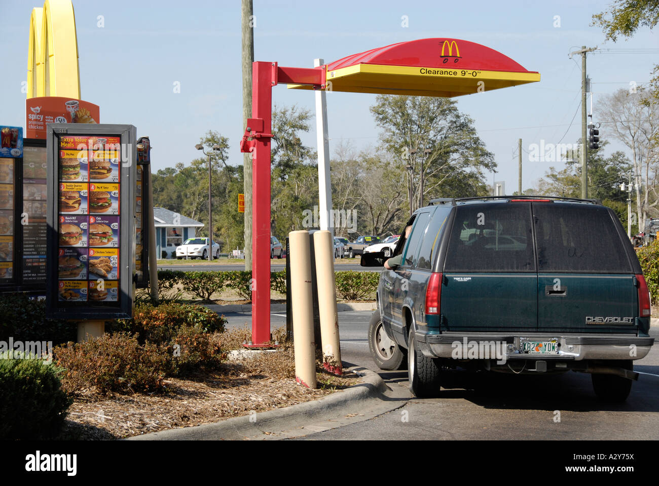 Cars use a drive through window to order and pick up fast food at a ...