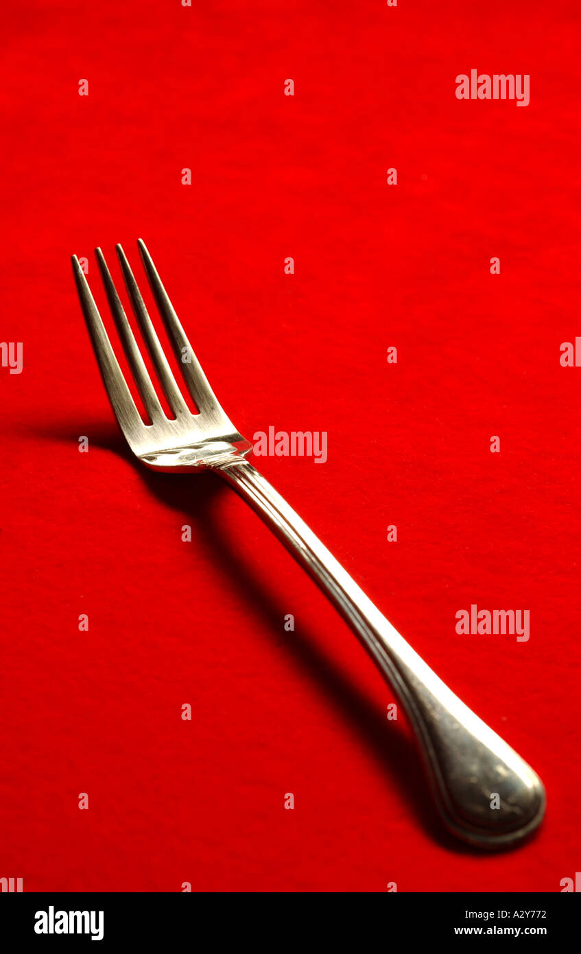 Color image of a dinner fork sitting on a red background Stock Photo ...