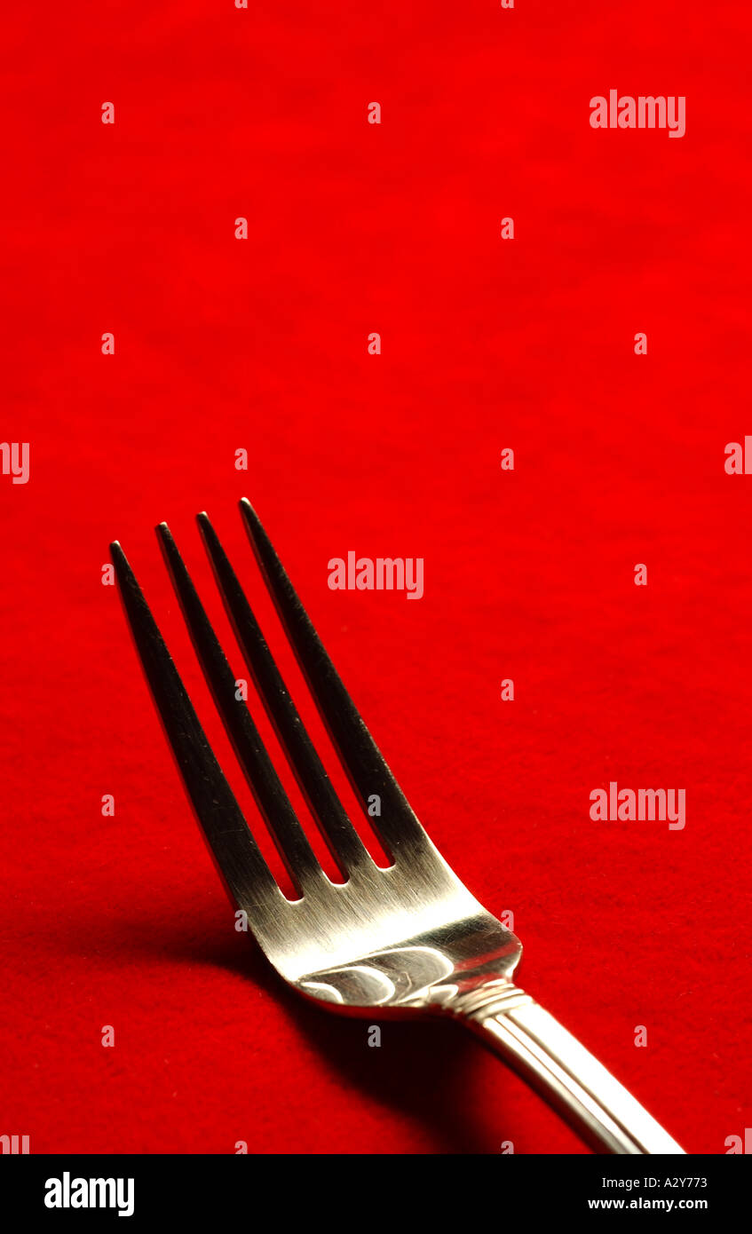 Color image of a dinner fork sitting on a red background Stock Photo ...