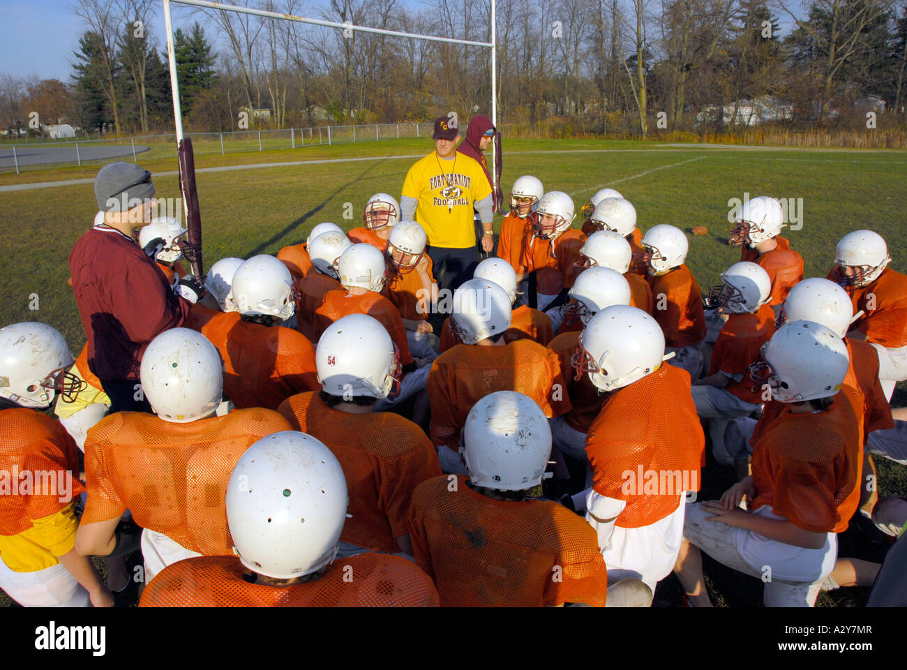 Football coach meeting with team to discuss finer points of the game ...