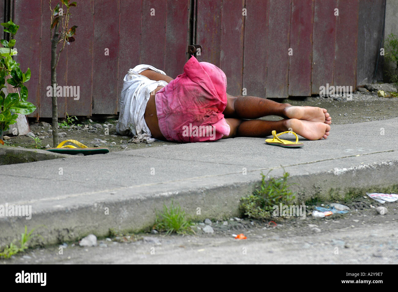 Homeless man on the curb in Maria Aurora Philippines Stock Photo - Alamy