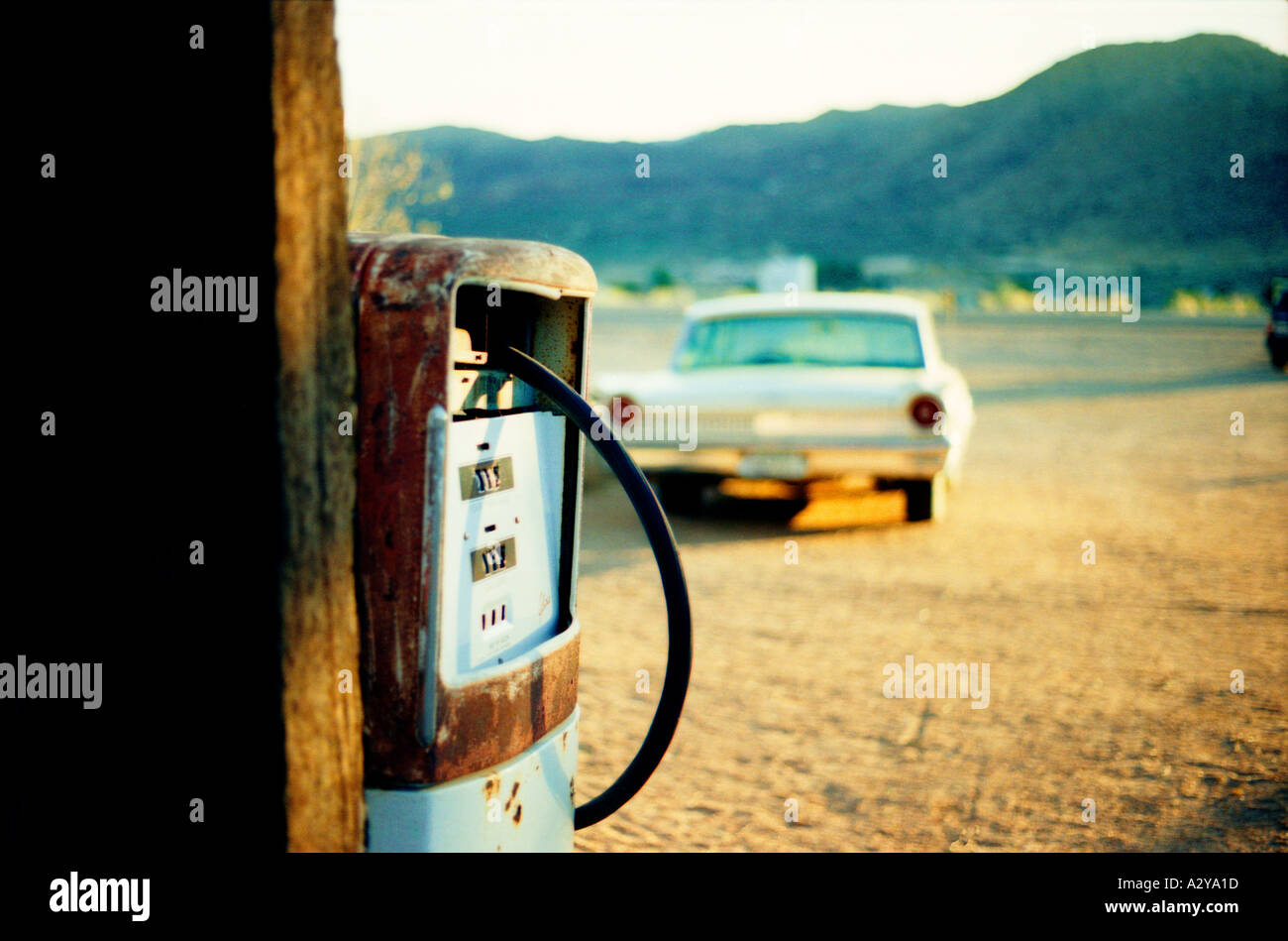 old rusty gas pump with car in background and mountains on old gas ...