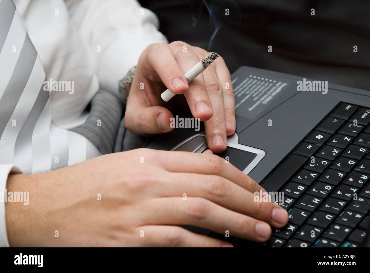 man with cigarette working on laptop computer Stock Photo - Alamy