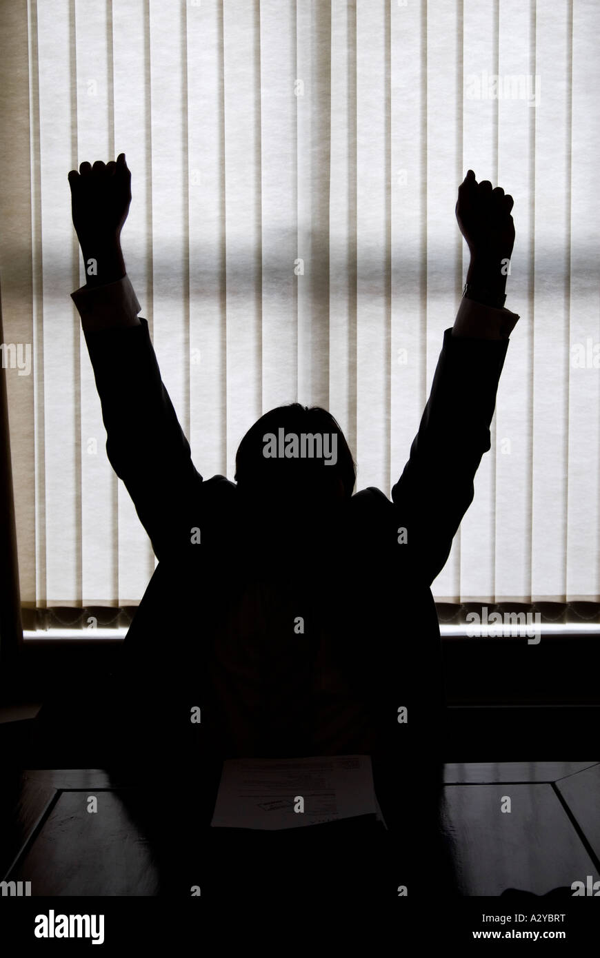 Silhouette of a business man raising his hands up in his office Stock ...