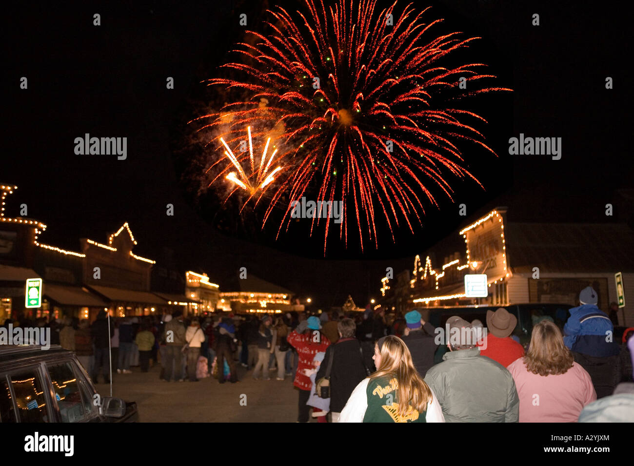 Image of a group of people in a street watching a fireworks display ...