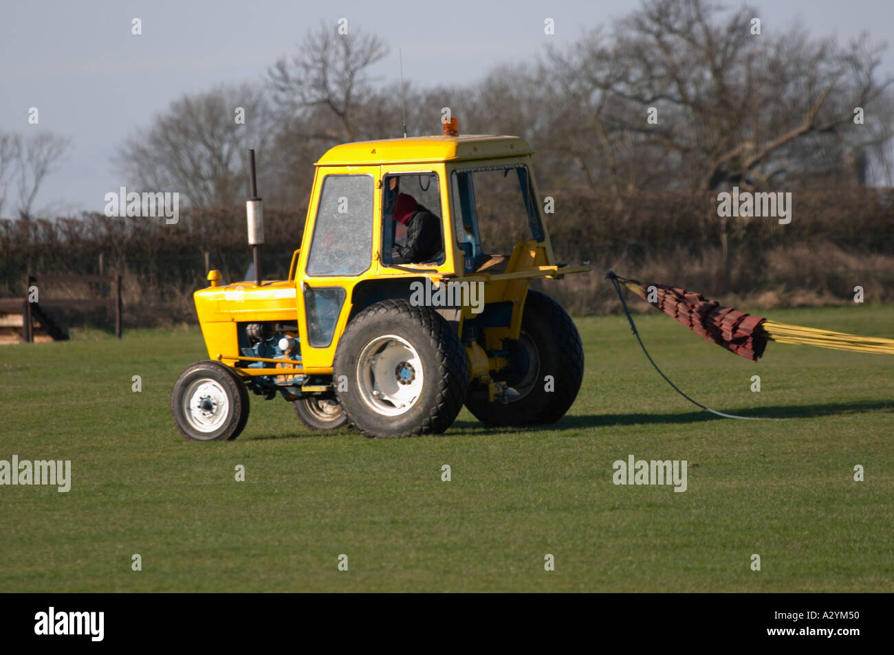 Yellow tractor towing a winch cable Stock Photo - Alamy