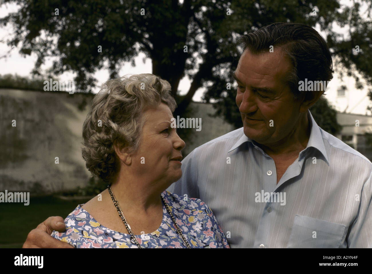 middle aged couple man looking lovingly into woman s eyes with his arm ...
