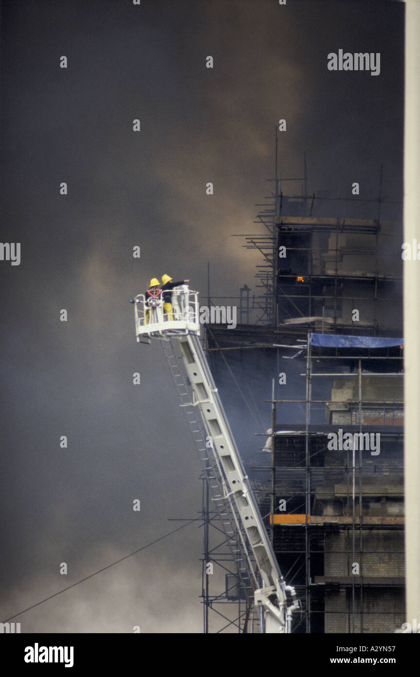 firemen putting out fire using extending mechanical hydraulic ladder ...