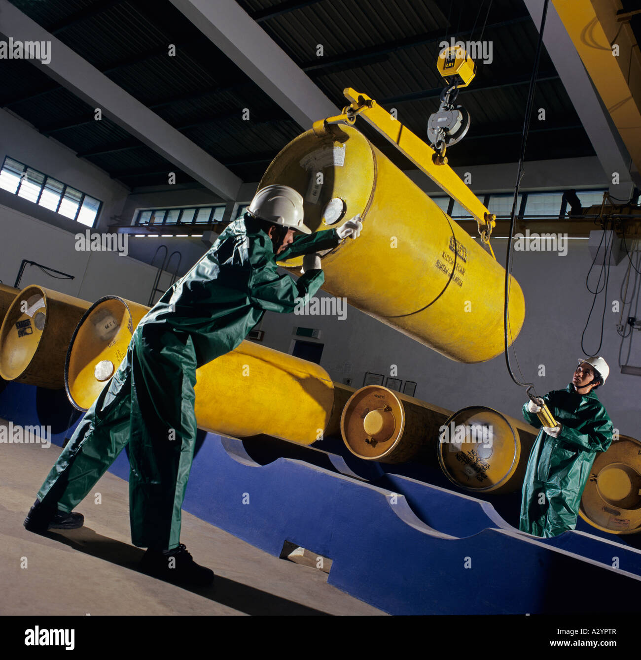 Operators lifting Chlorine tanks for use in water treatment plant ...