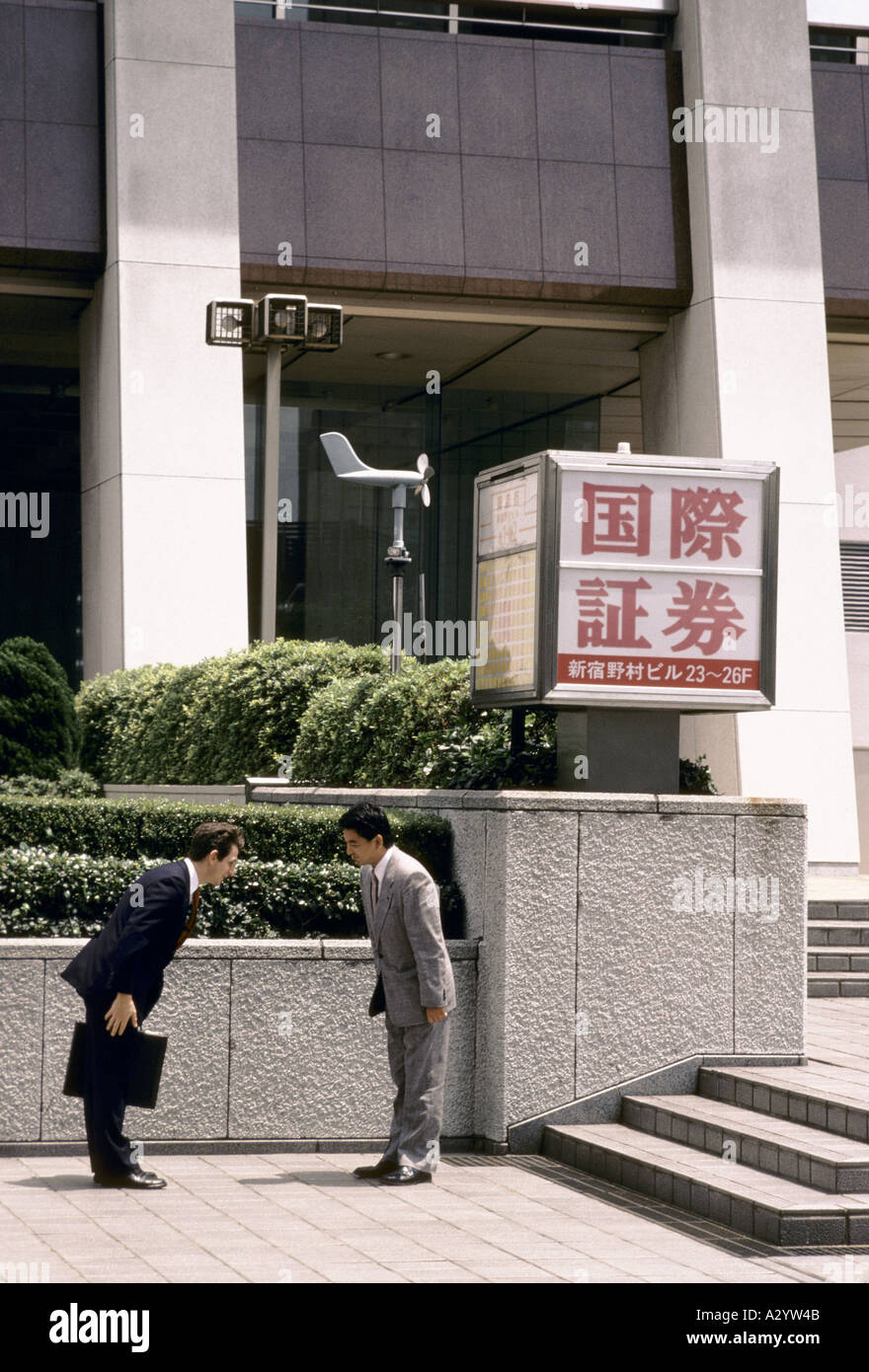 tokyo japan a western business man greets a japanese man outside of ...
