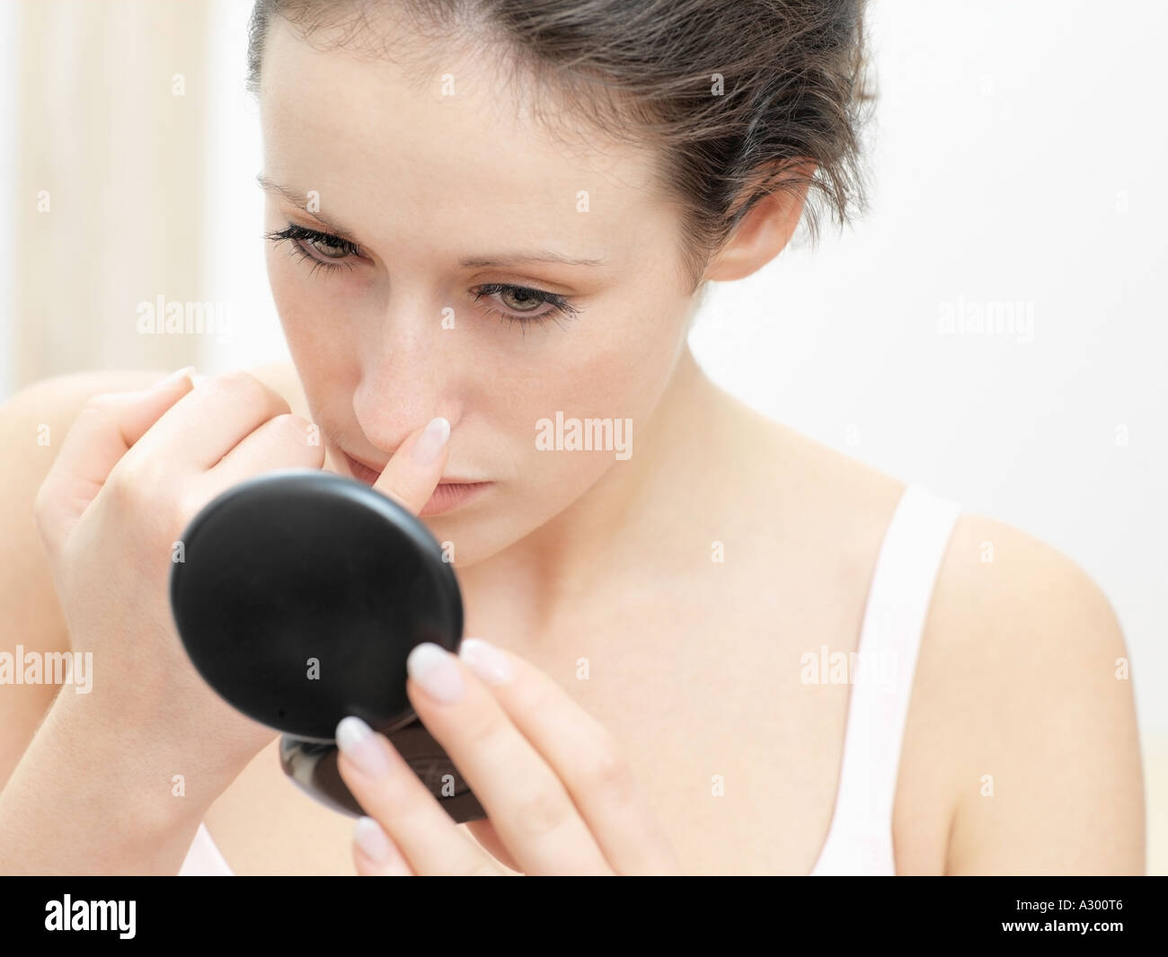 Model looking in compact mirror Stock Photo - Alamy