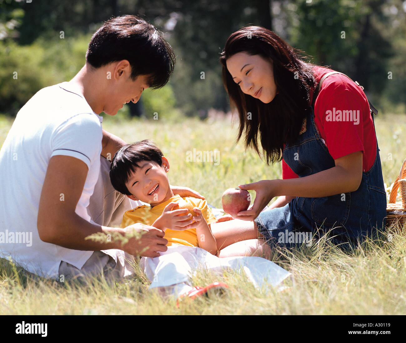 Chinese three people family playing in a grassland Stock Photo - Alamy