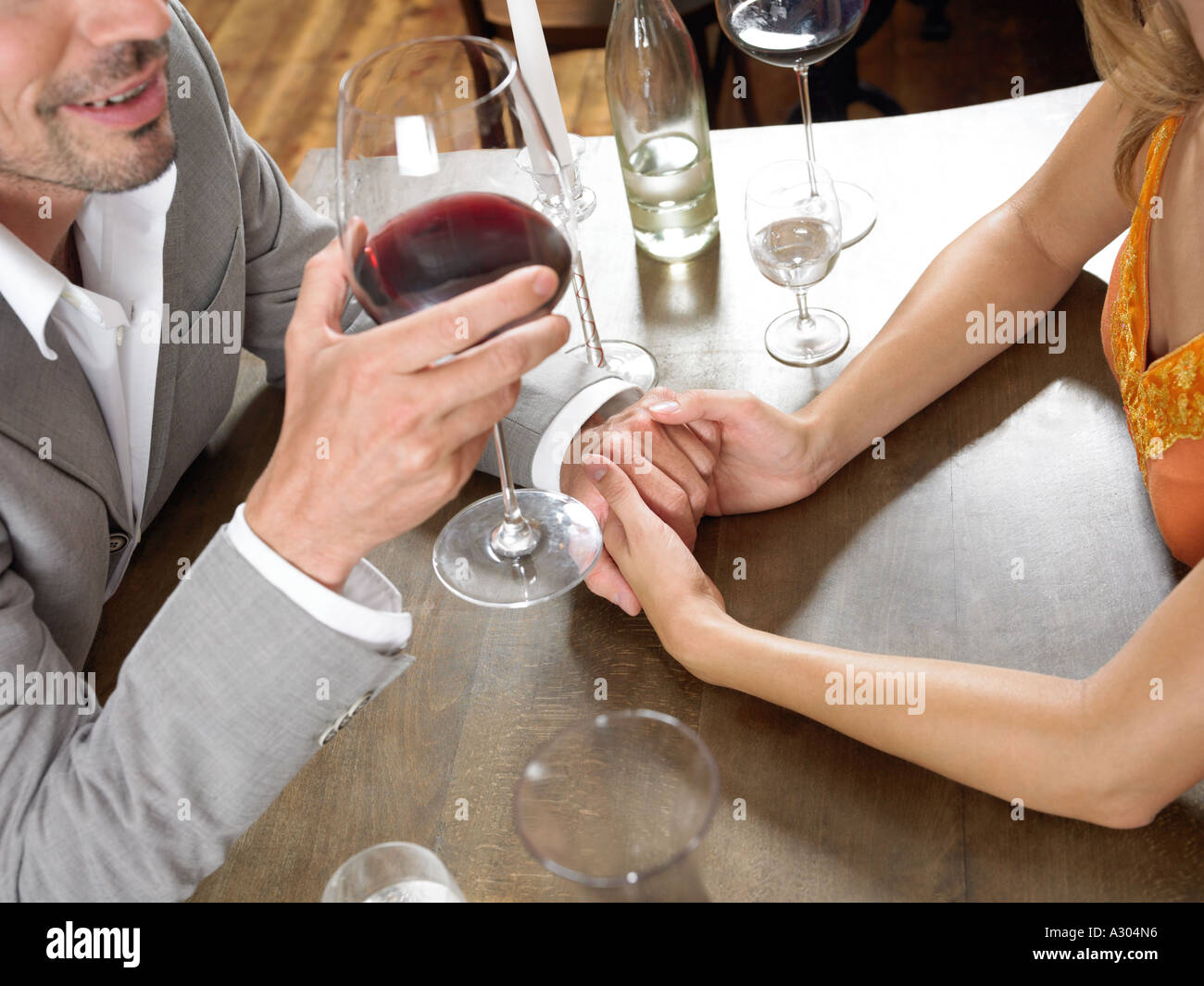 Couple holding hands at table Stock Photo - Alamy