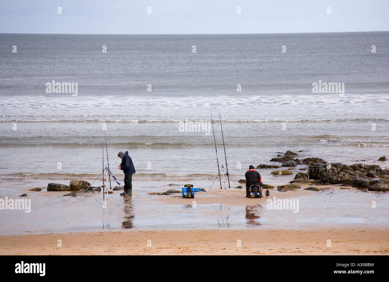Fisherman beach fishing on Dunstanburgh castle beach Northumberland ...