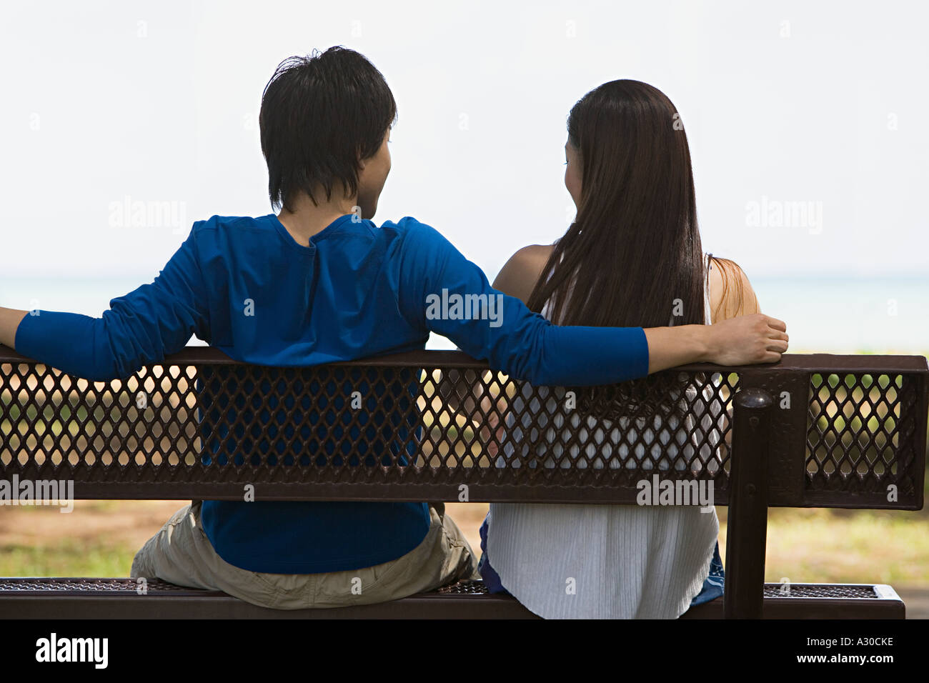 Couple sitting on bench Stock Photo - Alamy