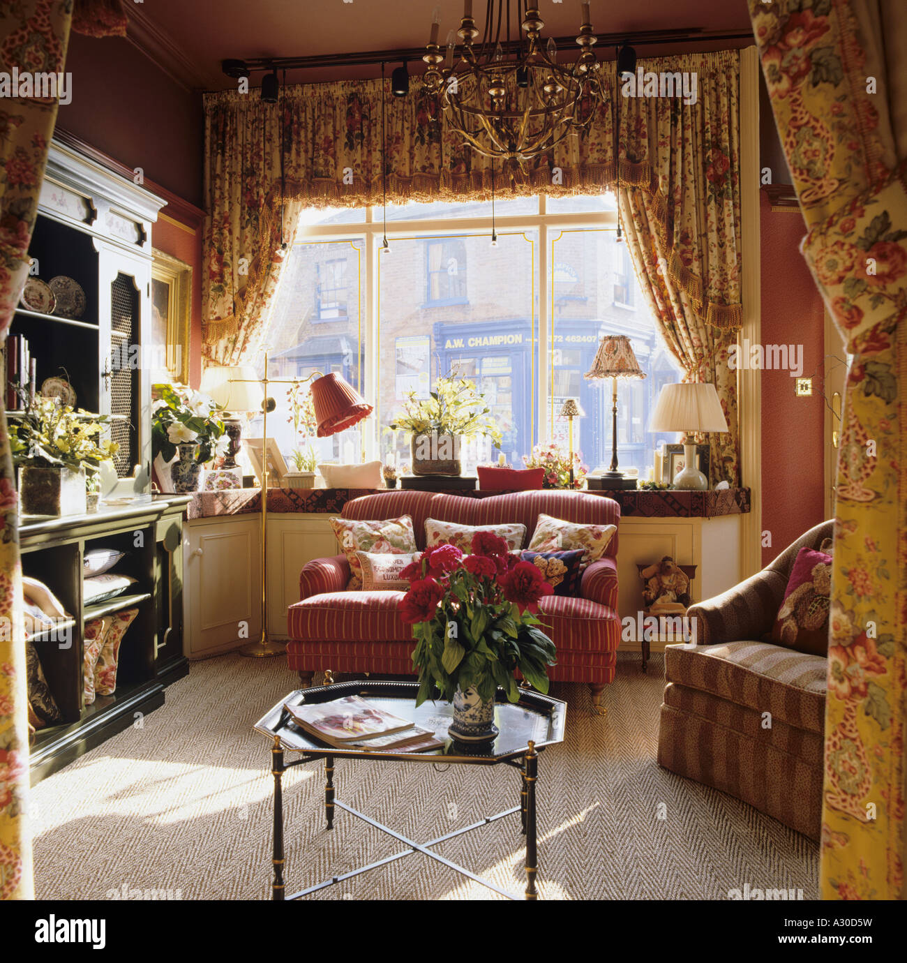 Sofa under living room window with curtain pelmet Stock Photo - Alamy