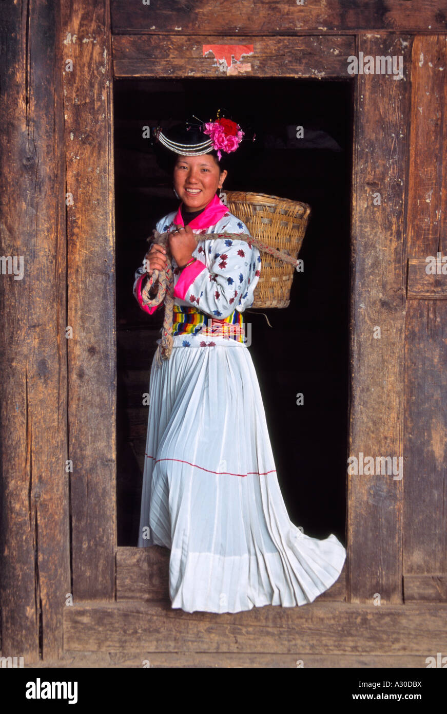 Matriarchal Mosuo woman by the door with praying flags Lugu Lake ...