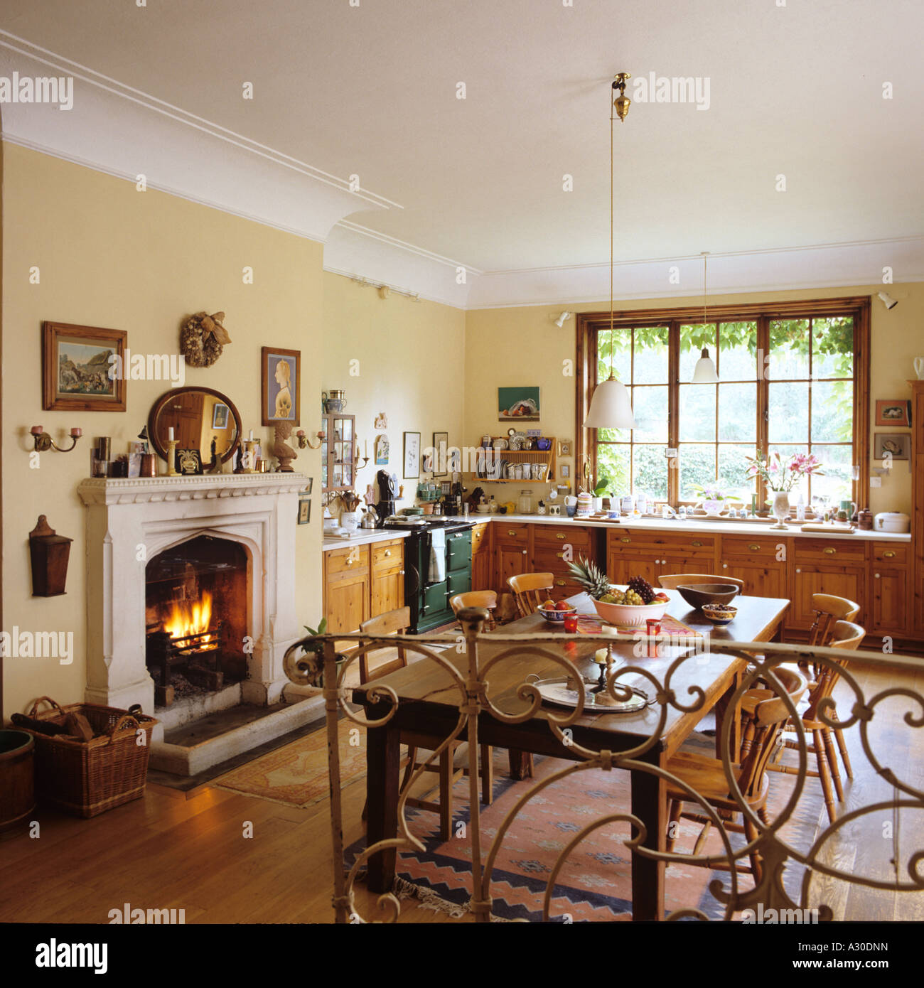 Open plan kitchen with lit fire and wrought iron detail Stock Photo - Alamy