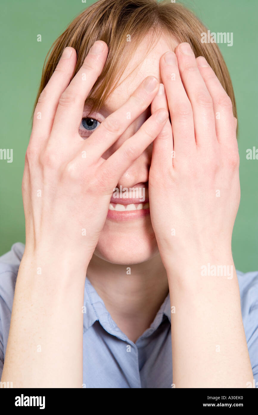 Young woman with hands over face Stock Photo - Alamy