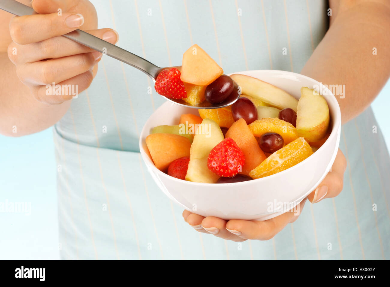 WOMAN EATING FRESH FRUIT SALAD Stock Photo - Alamy