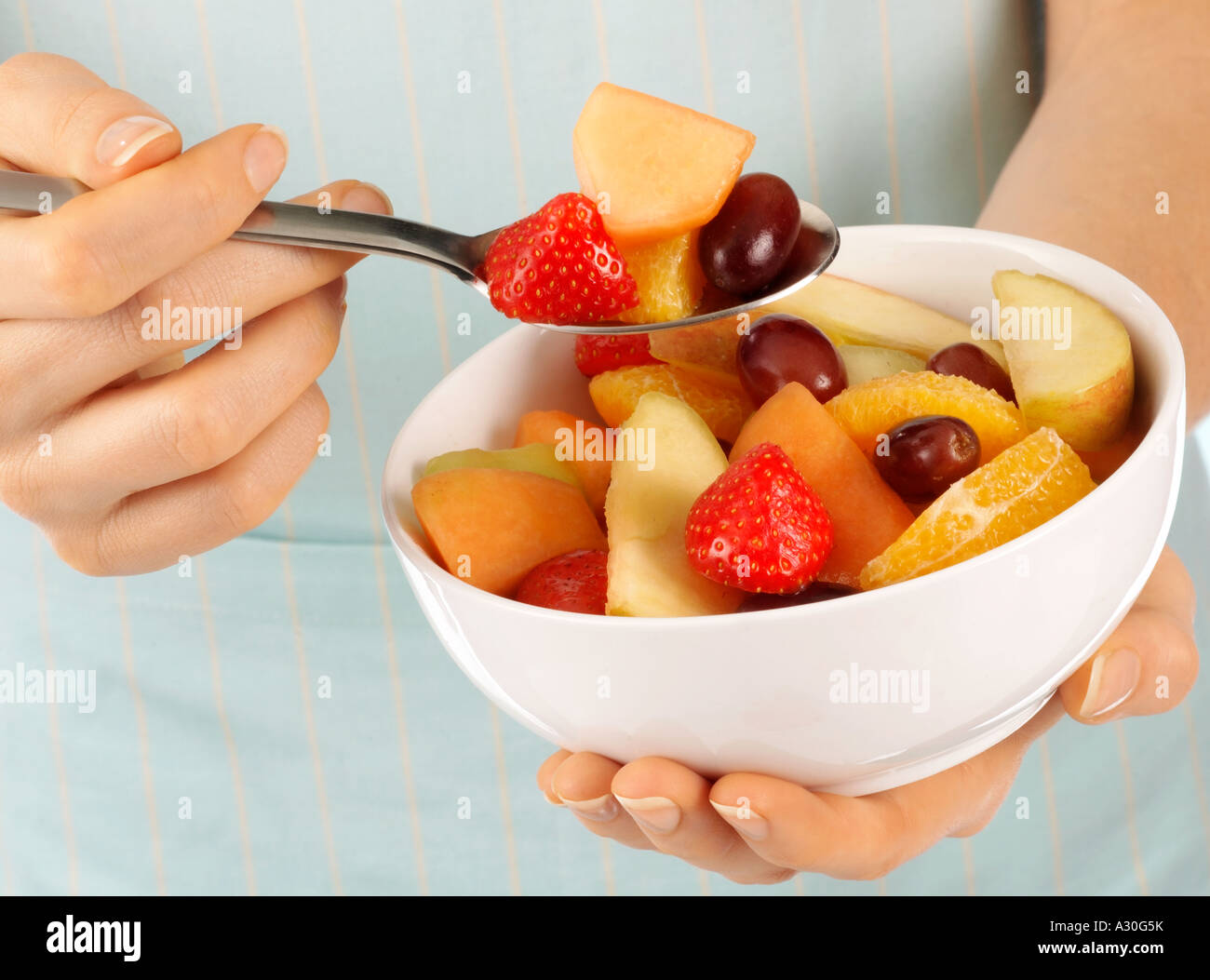 WOMAN EATING FRESH FRUIT SALAD Stock Photo - Alamy