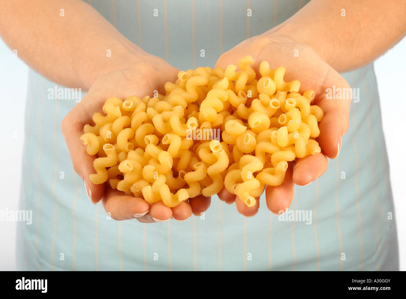 WOMAN WITH HANDFUL OF CURLY PASTA OR CELLANTANI PASTA Stock Photo - Alamy