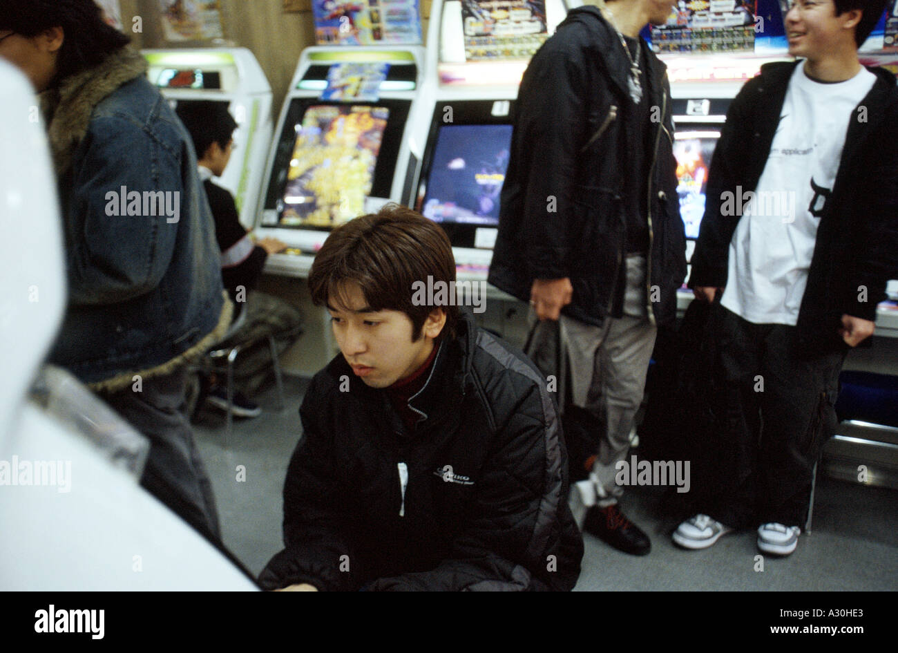 Young men play on computer games in a video game arcade parlour in ...