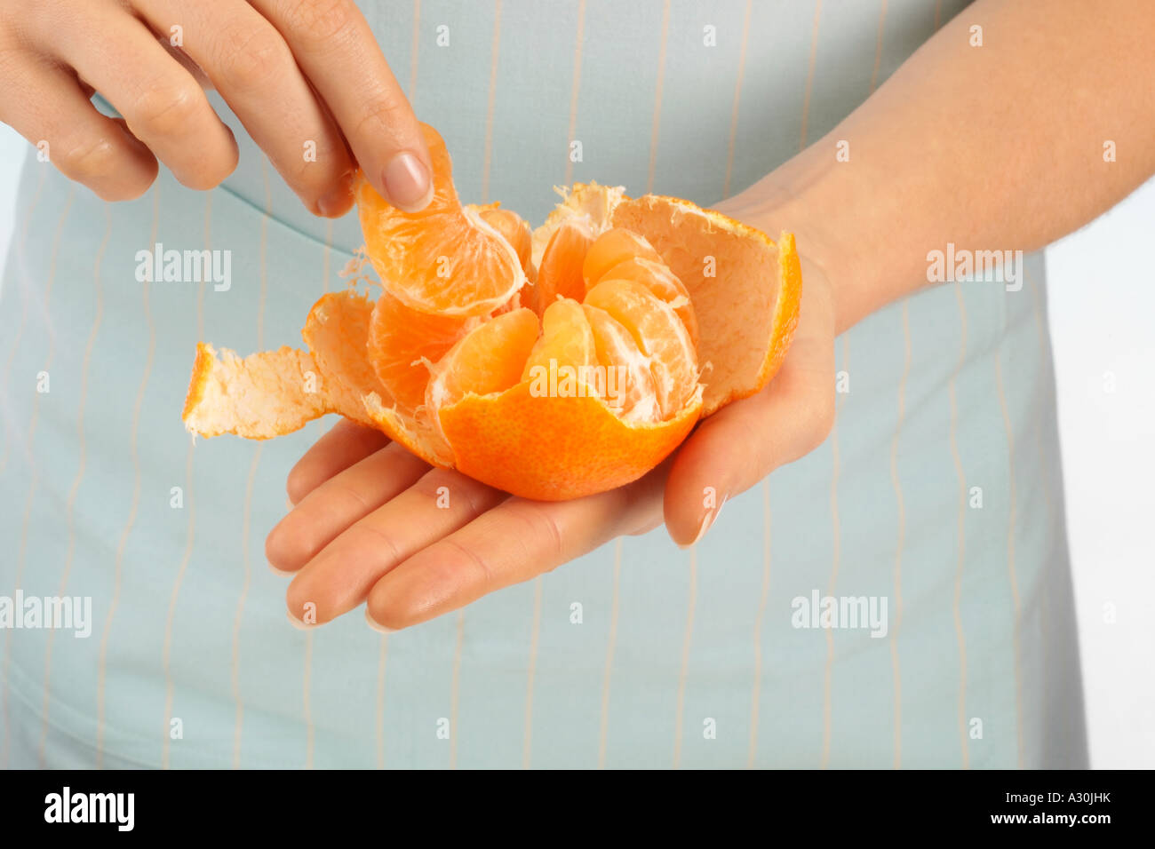 WOMAN PEELING TANGERINE Stock Photo - Alamy