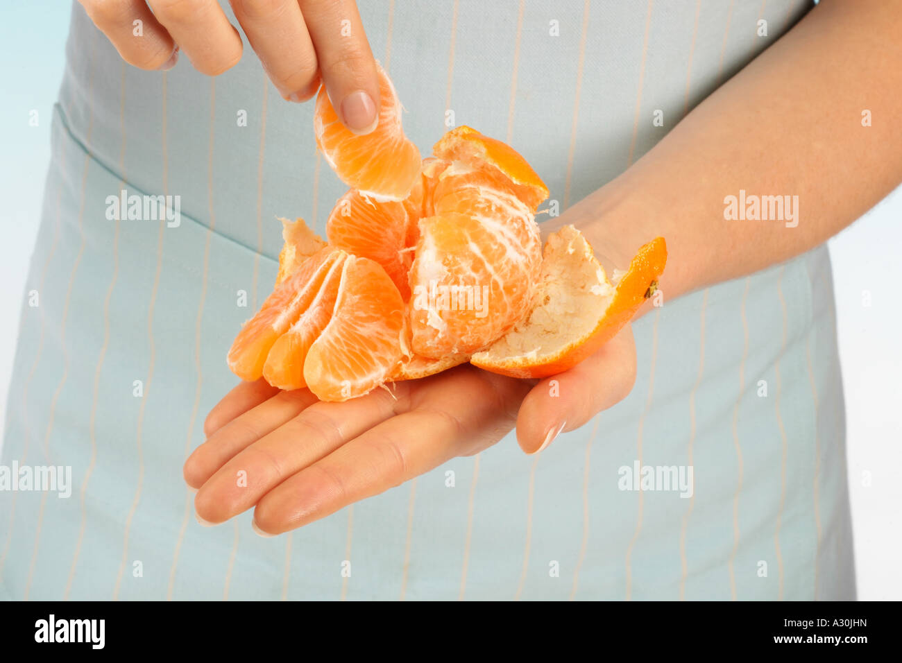 WOMAN PEELING TANGERINE Stock Photo - Alamy