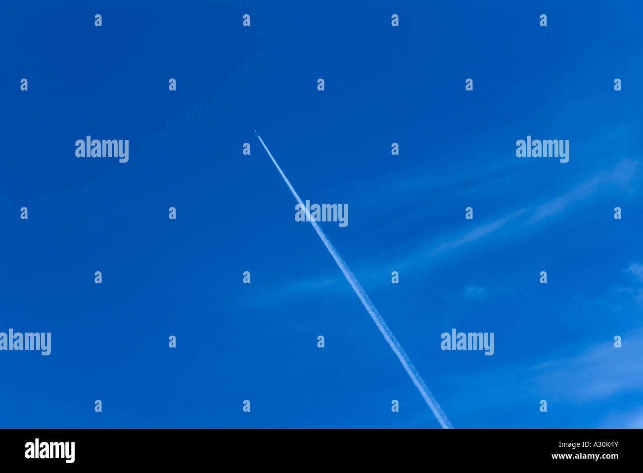 Jet plane contrail below cirrus clouds Stock Photo - Alamy