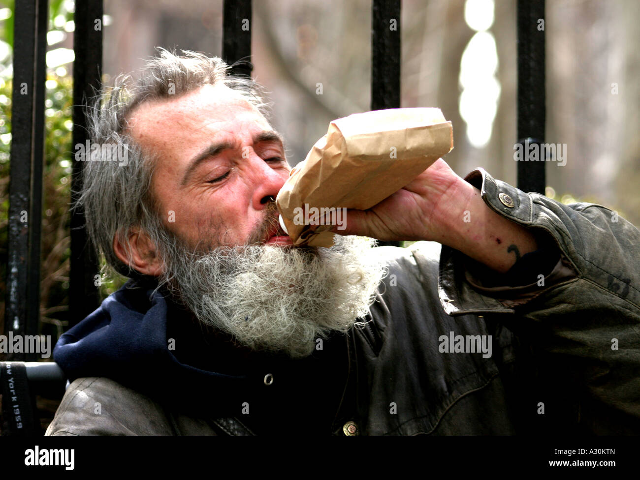 Homeless man having a drink Stock Photo - Alamy