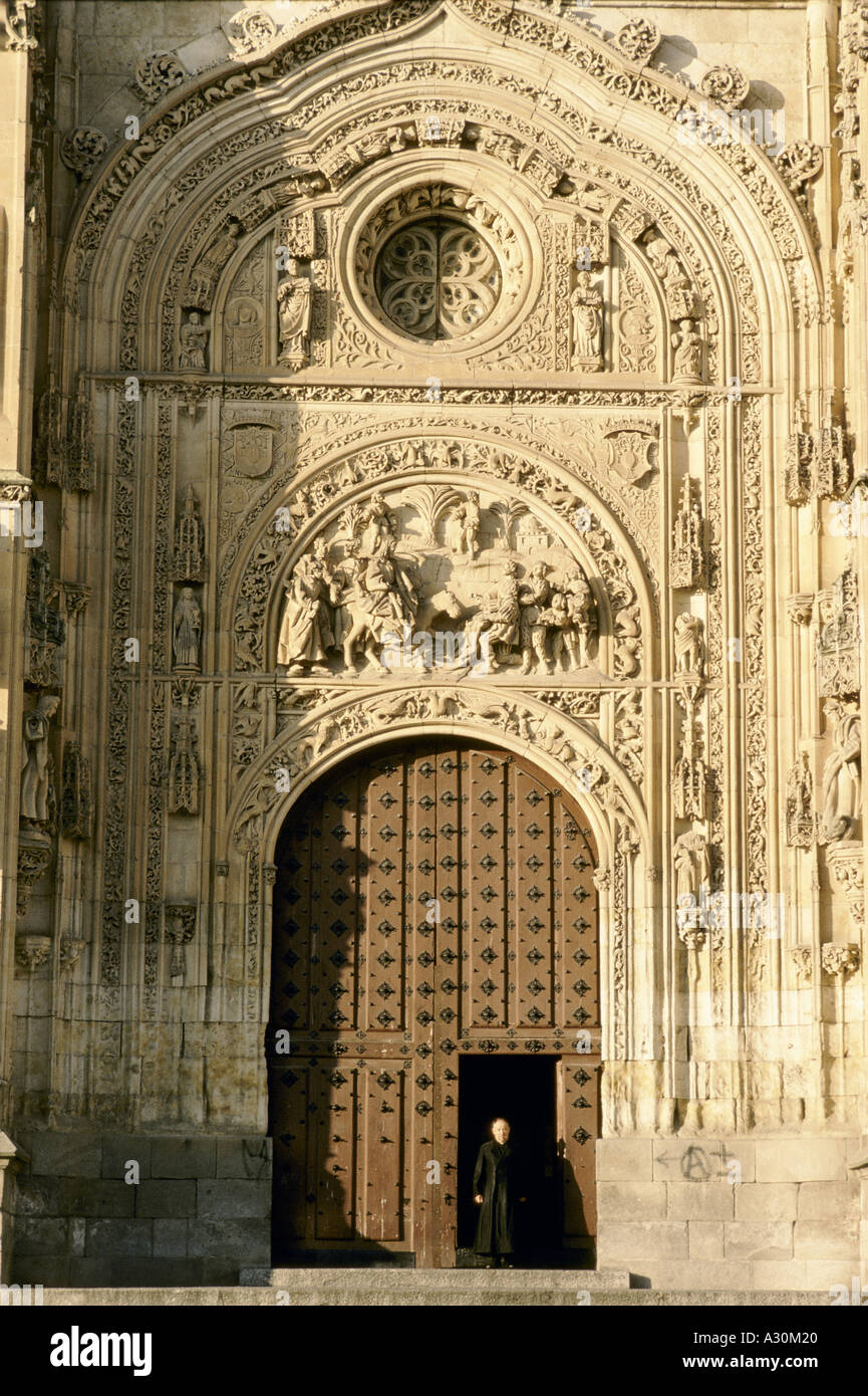 priest standing outside the main arched double door of the highly ...