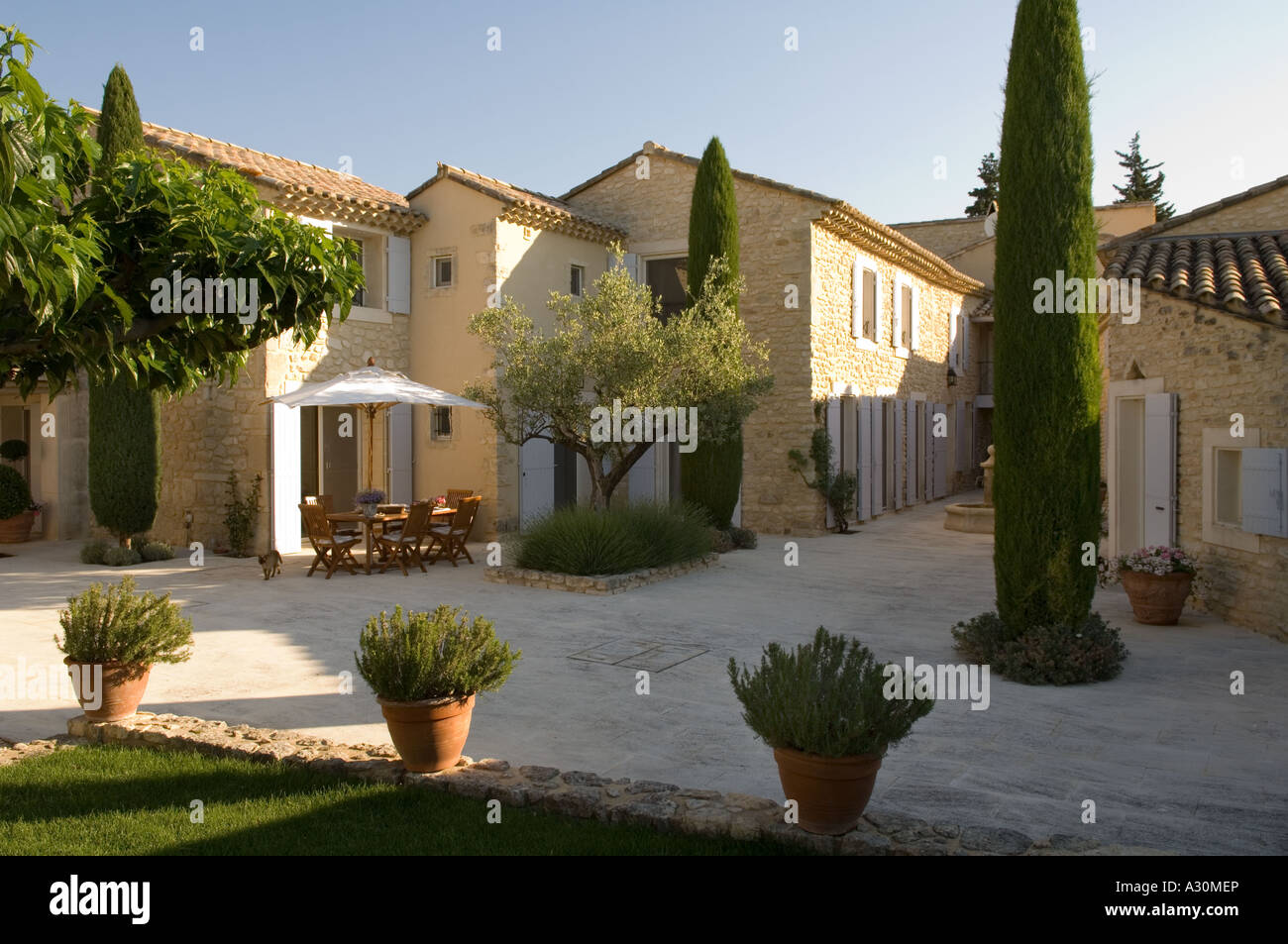 Courtyard exterior of Provençal house with trees and pot plants Stock ...