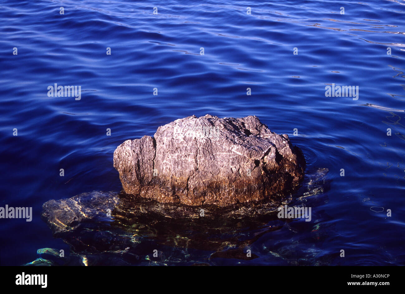 Rock emerging from the sea Stock Photo - Alamy