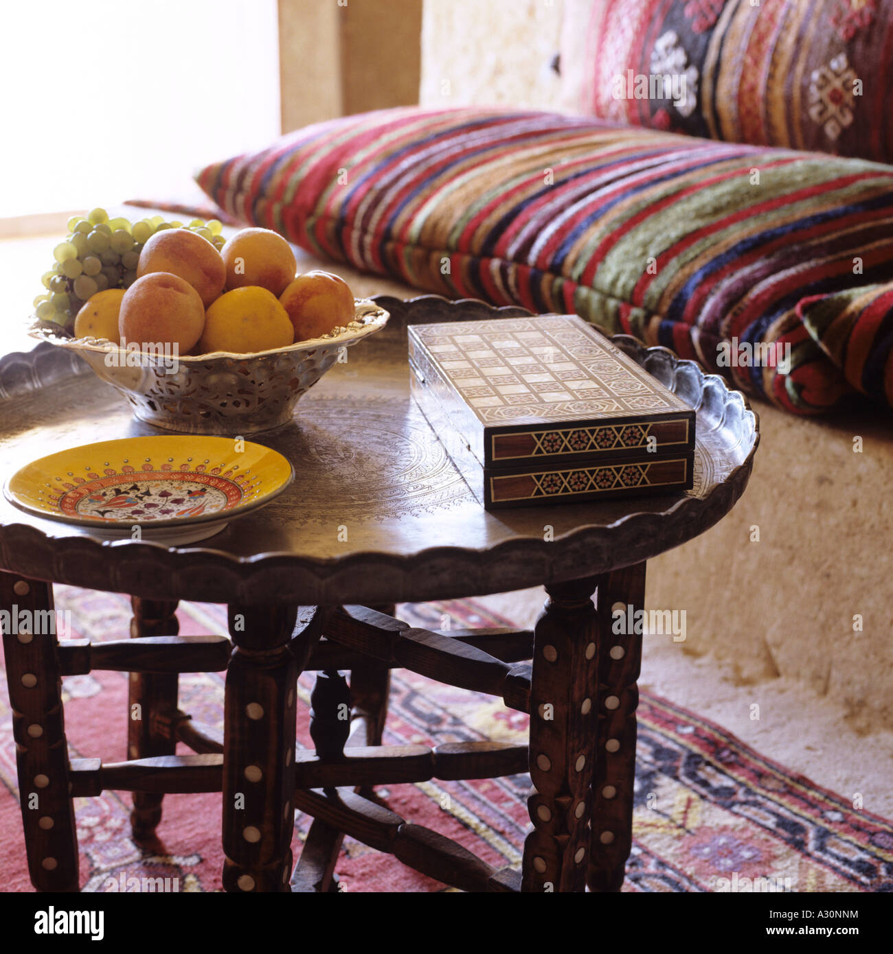 Moroccan inlaid table with fruit and chessboard and striped bench ...